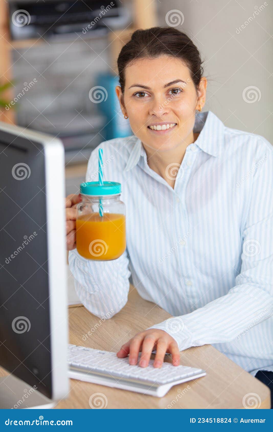 Businesswoman Using Computer and Holding Fresh Juice Stock Photo ...