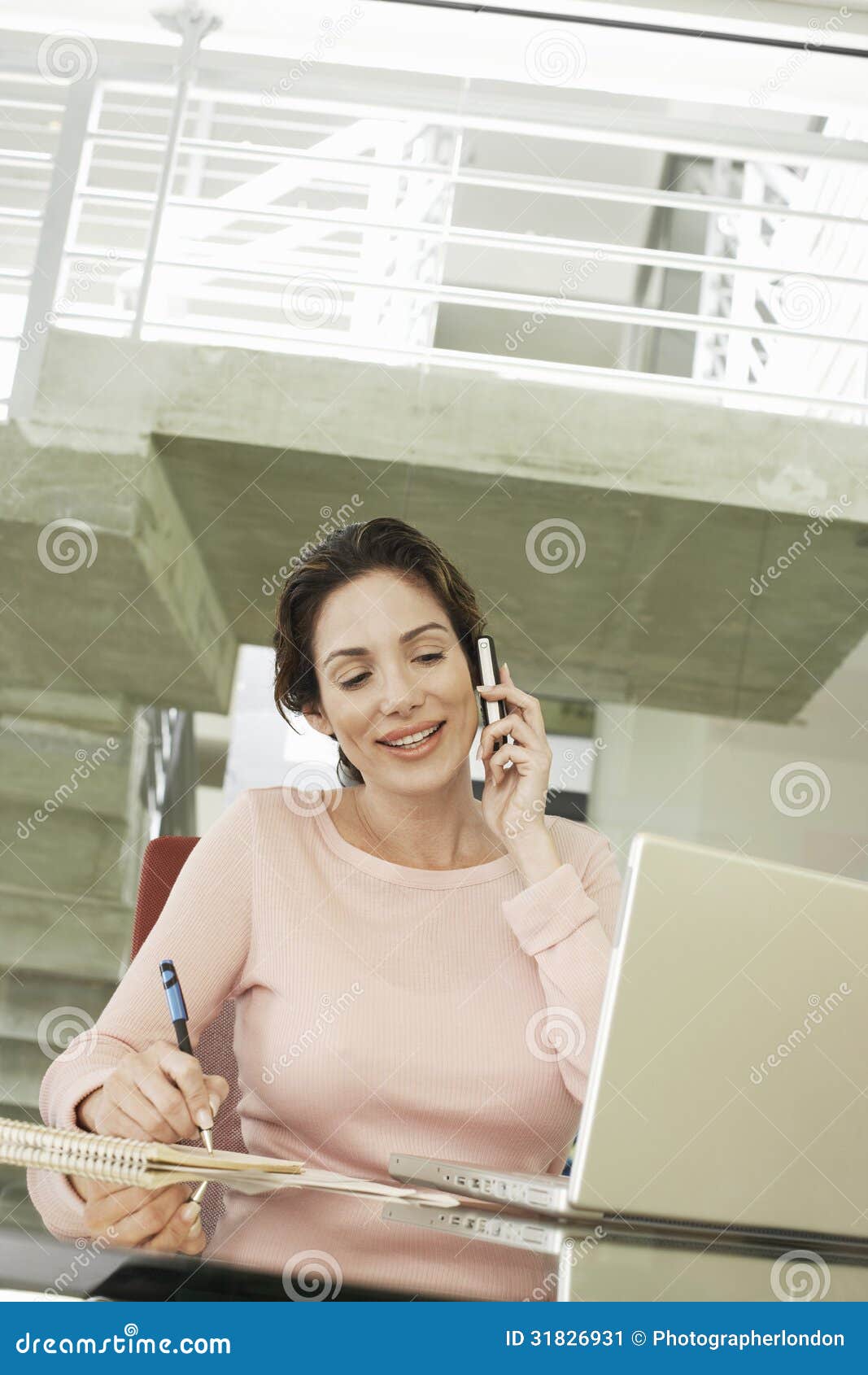 Businesswoman Using Mobile Phone while Writing on Notepad Stock Image ...