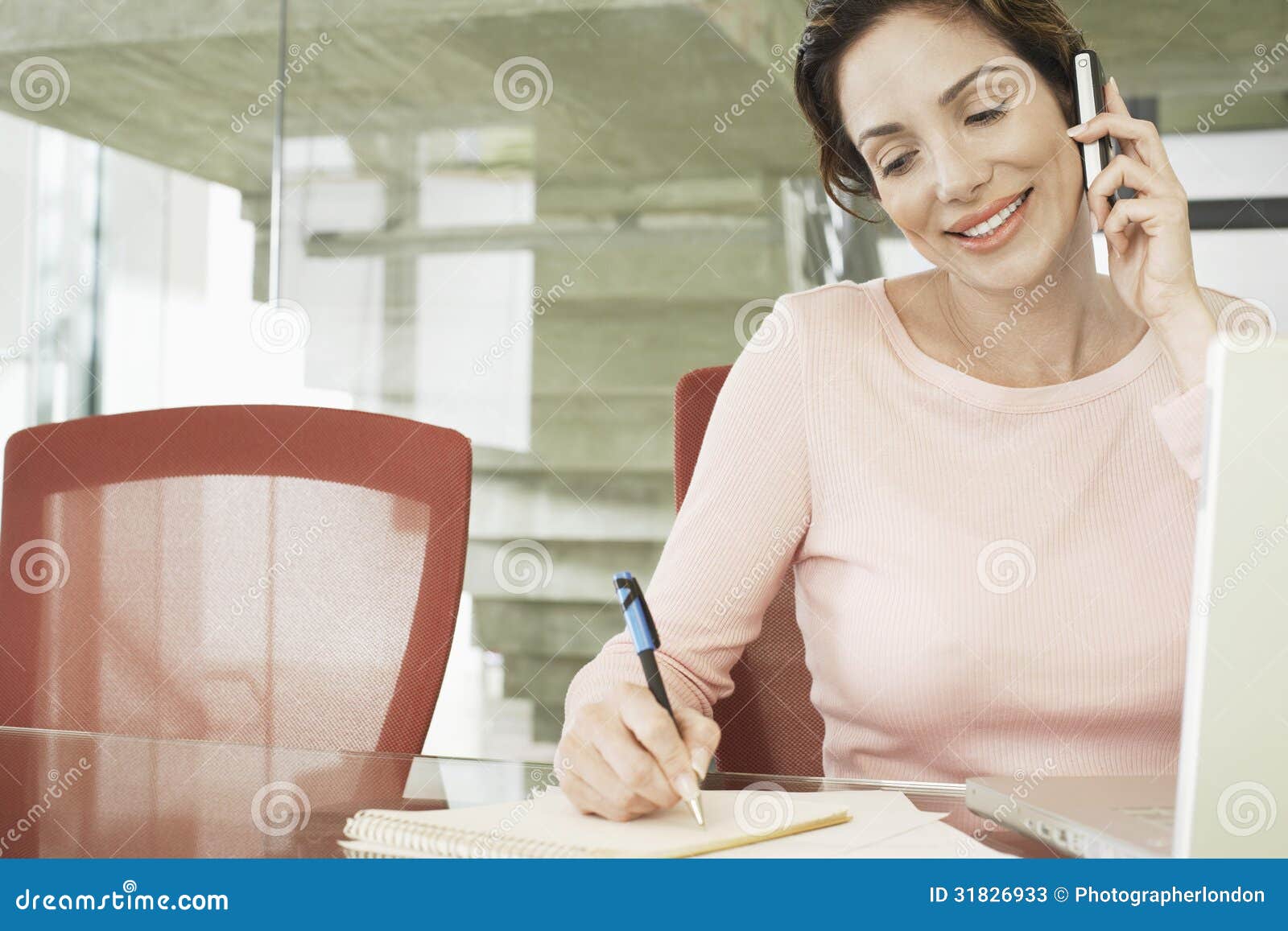 Businesswoman Using Mobile Phone while Writing on Notepad Stock Image ...