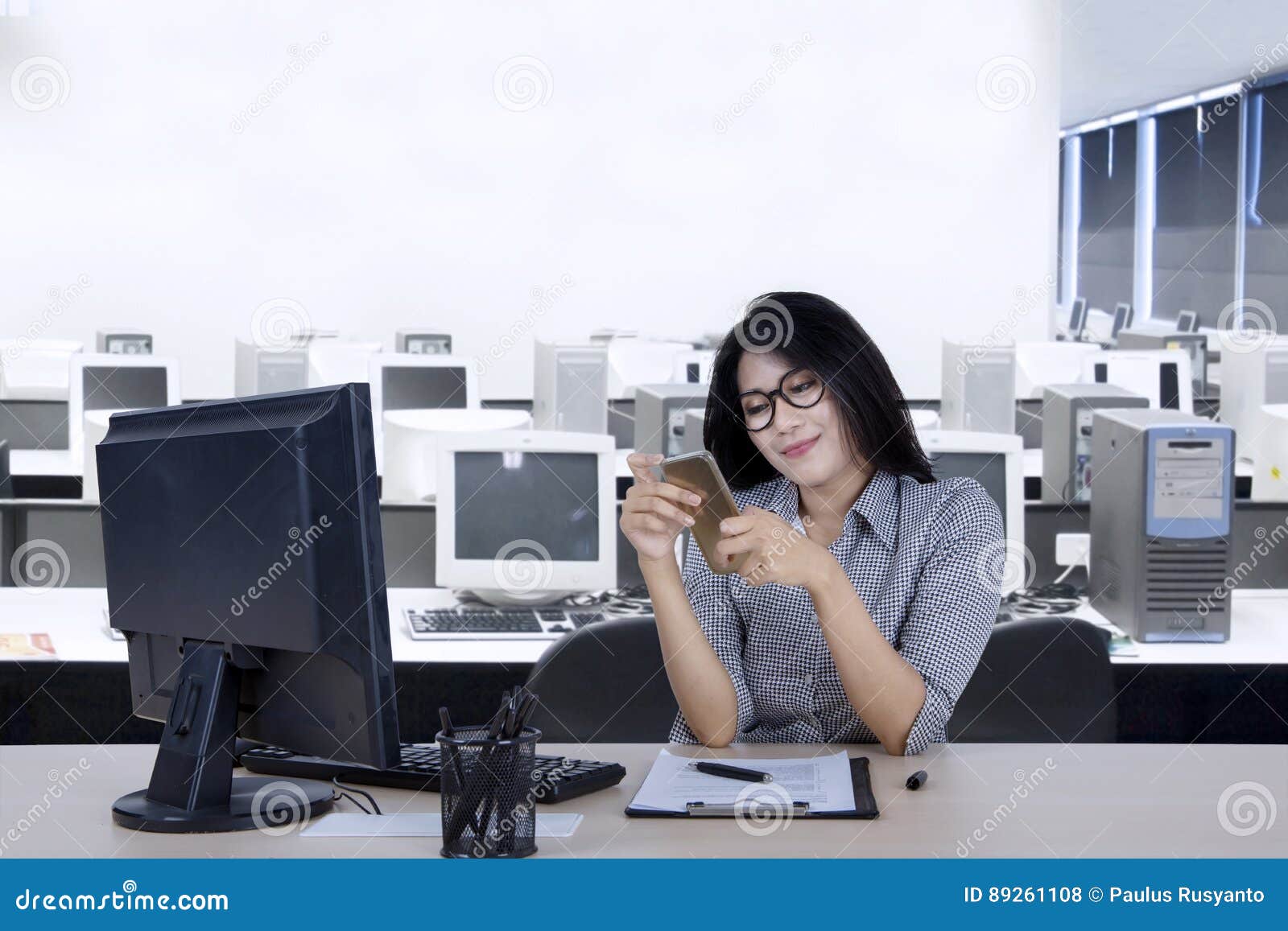 Businesswoman Using a Smartphone in the Workplace Stock Photo - Image ...
