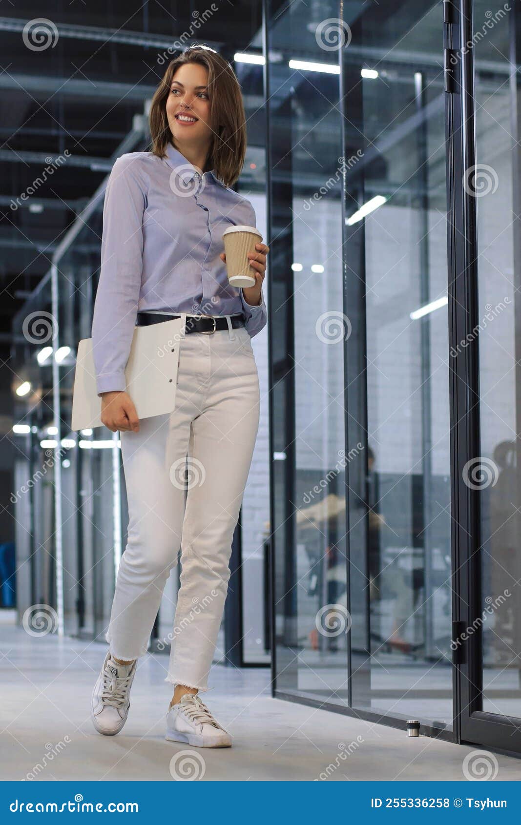 Businesswoman Walking Along the Office Corridor with Documents. Stock ...