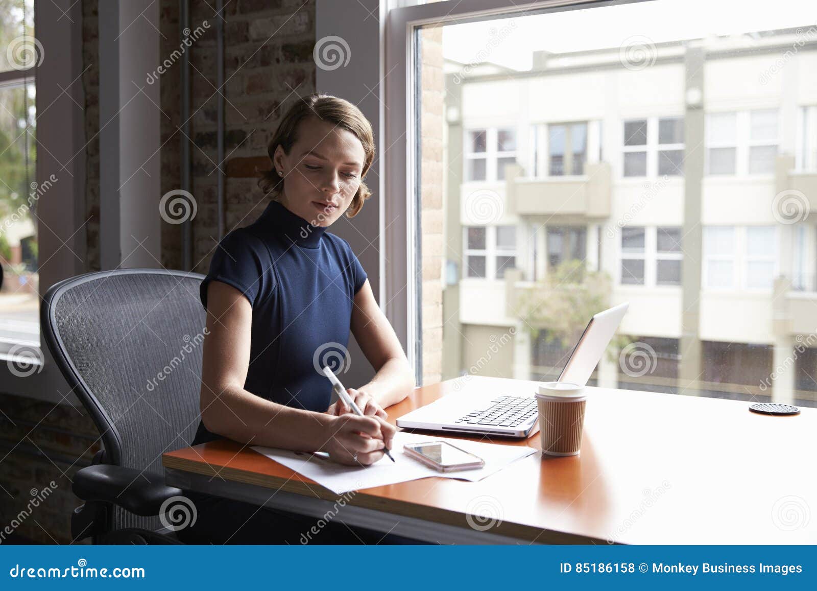 Businesswoman Working on Laptop and Making Notes on Document Stock ...