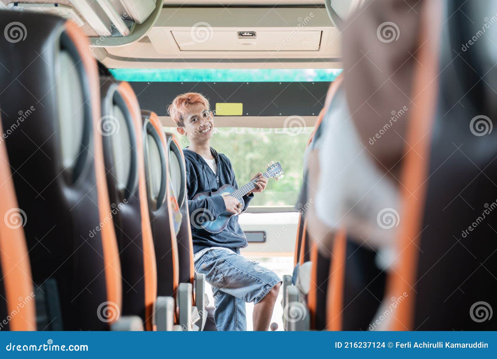A Busker Sings While Using An Ukulele Instrument And The Bus Passengers ...