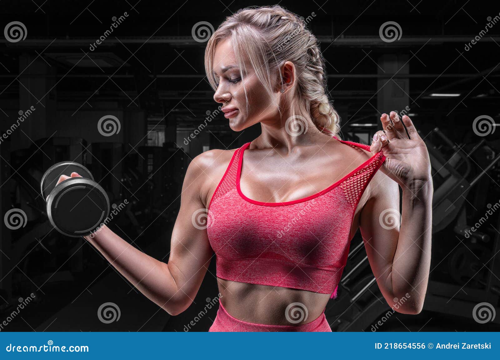 Busty Blonde In A Pink Tracksuit Posing In The Gym With Dumbbells