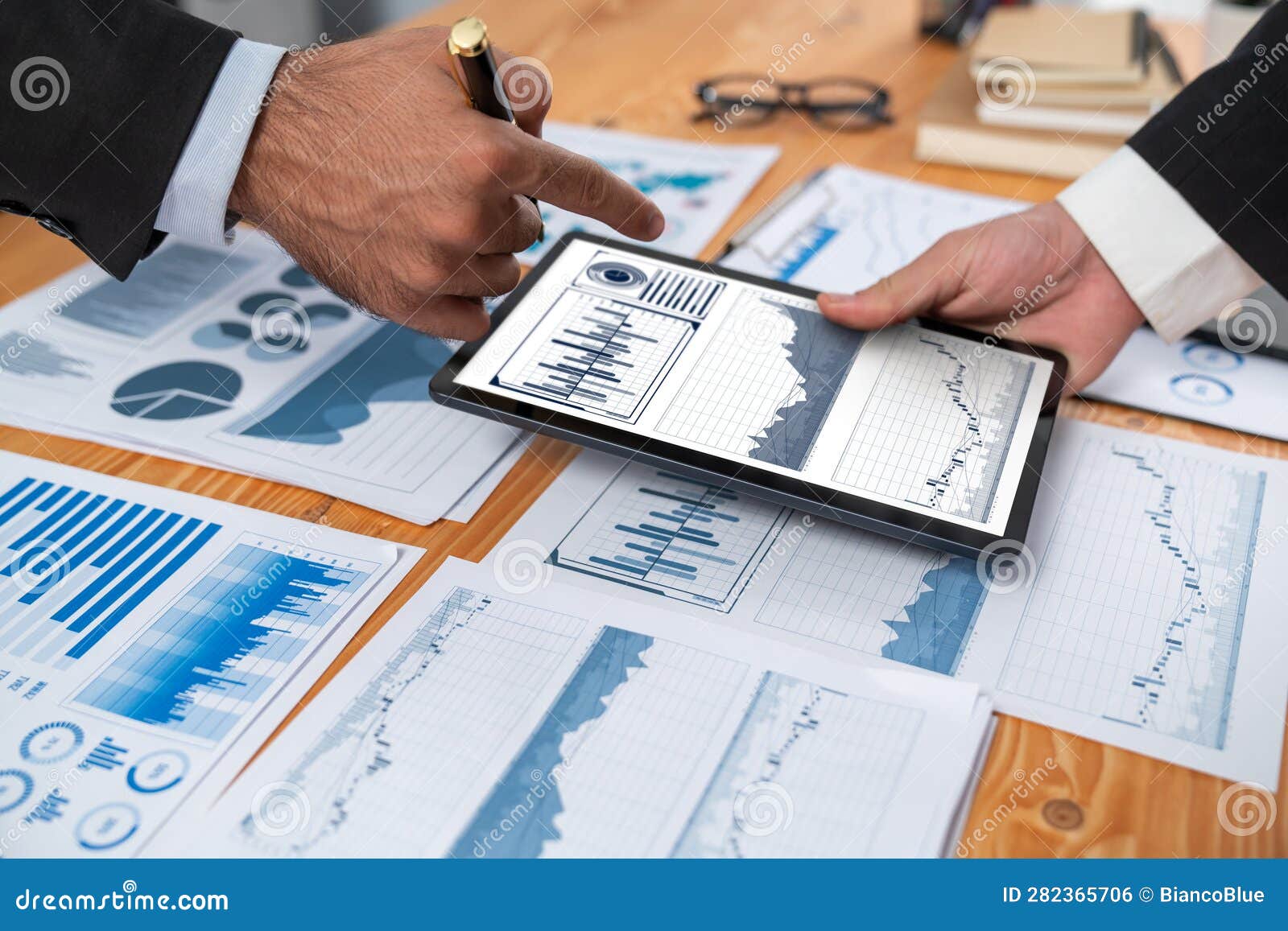 Busy Analyst Team Discussing Financial Data on Tablet. Fervent Stock ...