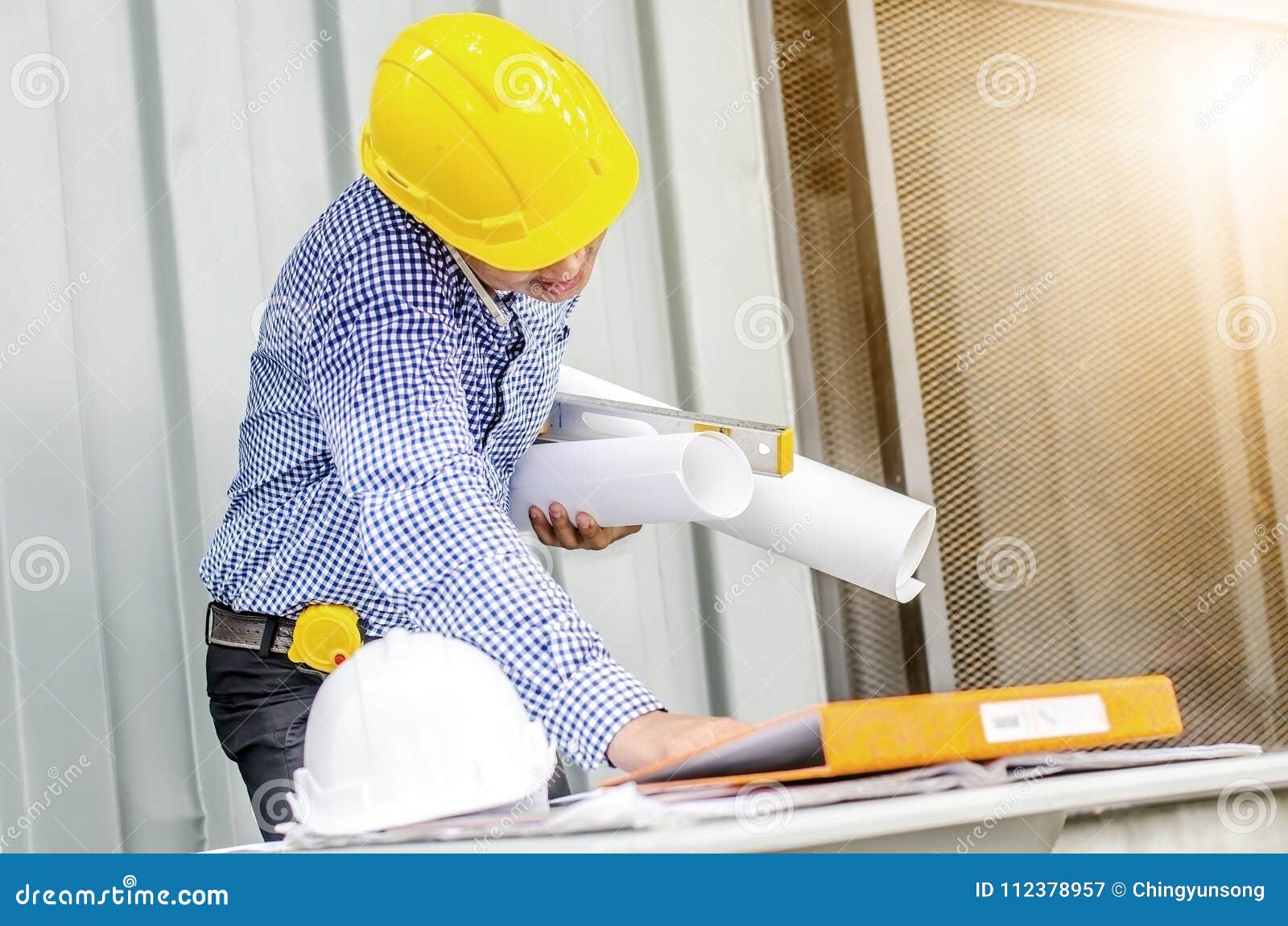 Busy Construction Engineer Talking on Phone while Carrying Blueprints ...