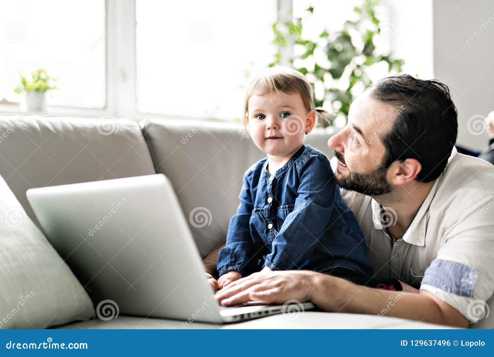 Busy Father Working on Laptop with Baby in Front Stock Photo - Image of ...