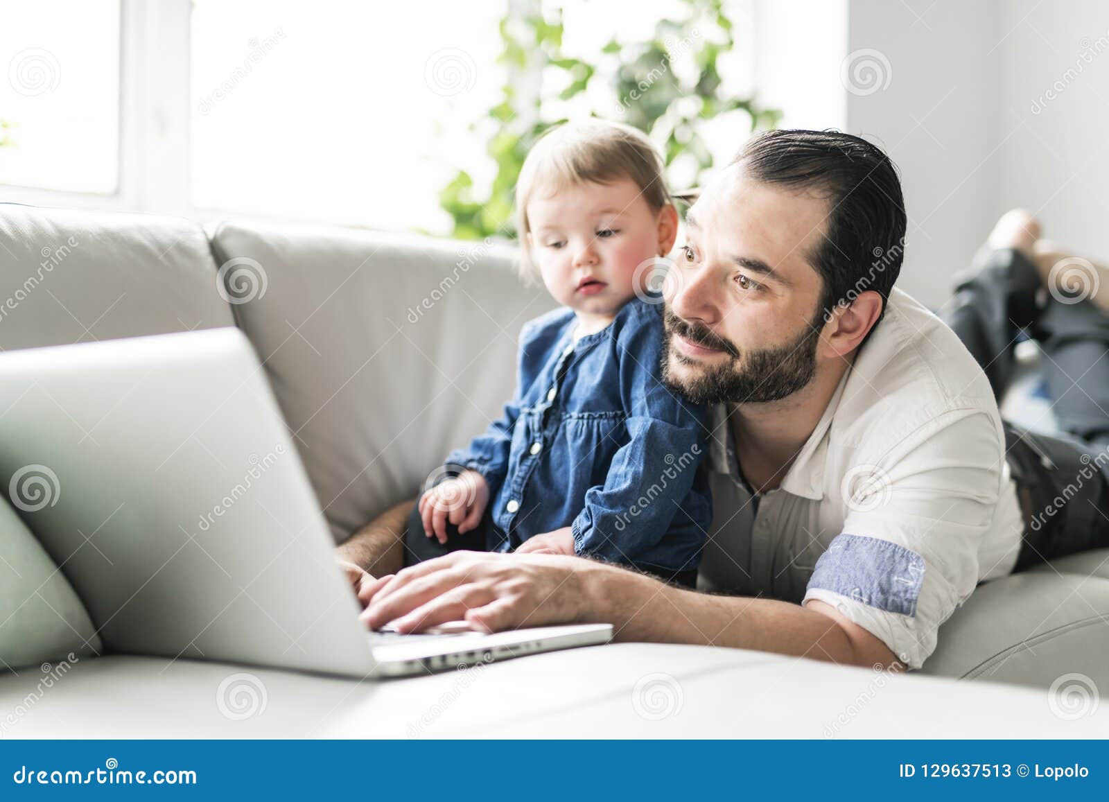 Busy Father Working on Laptop with Baby in Front Stock Image - Image of ...