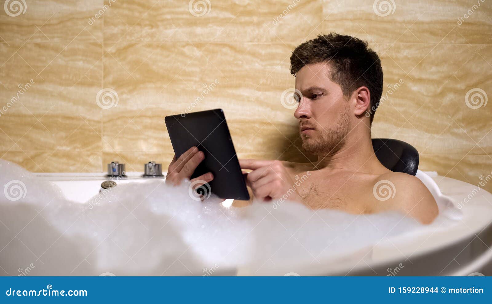 Busy Man Taking Bath and Looking through Documents on Tablet ...