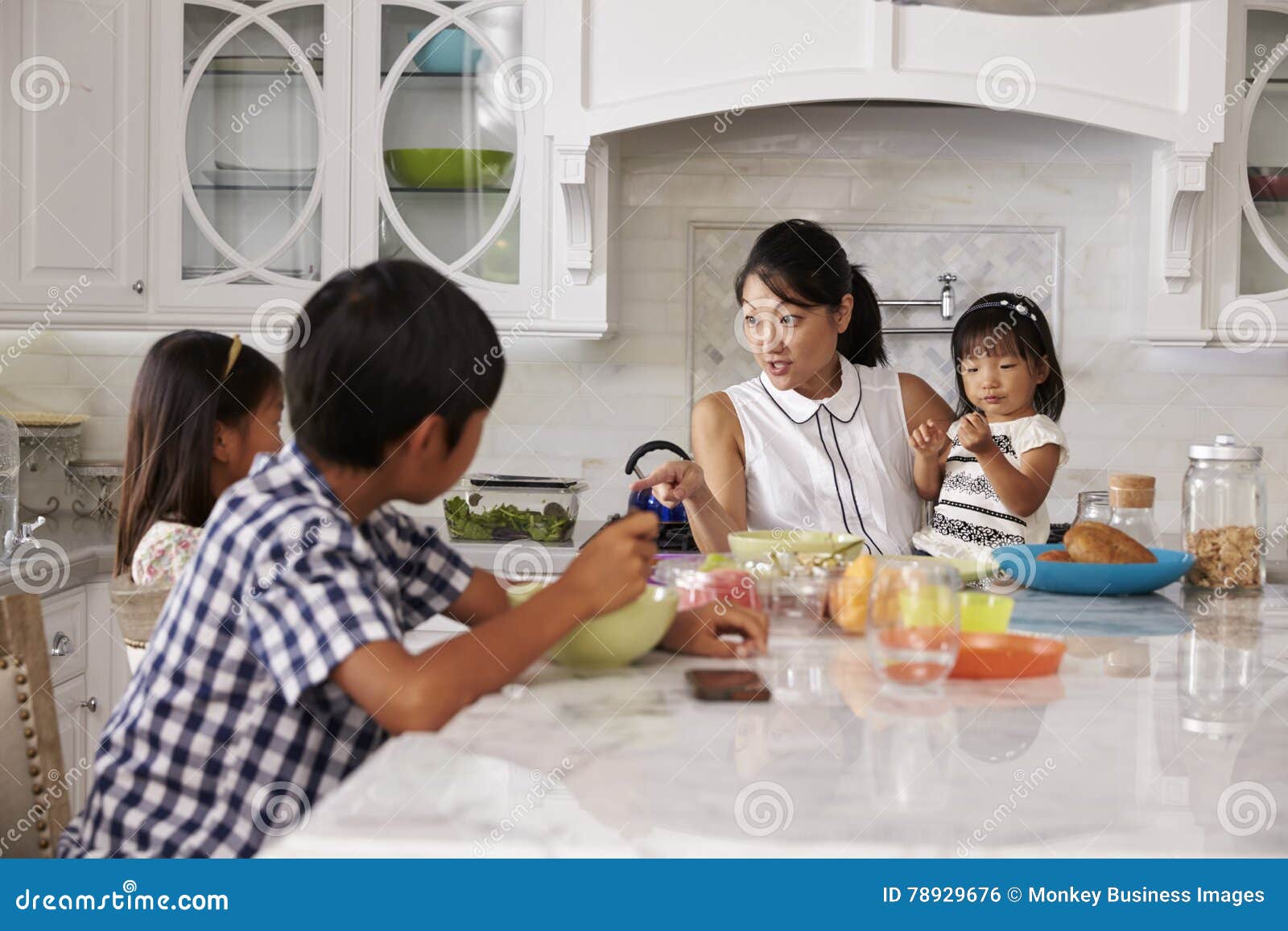 Busy Mother Organizing Children at Breakfast in Kitchen Stock Photo ...