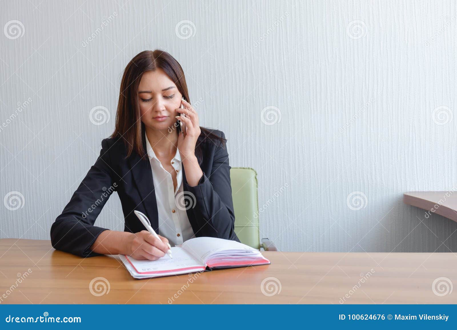 Busy Secretary is Answering Call and Writing Memo at the Same Time ...