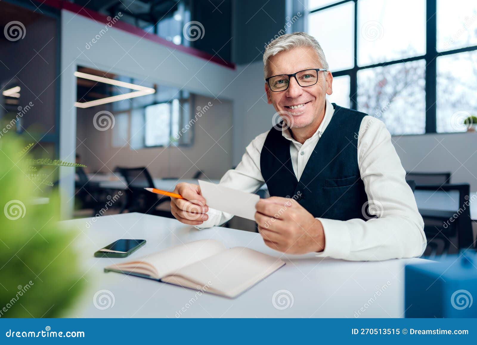 Busy Senior Man Sitting at Office Desk with Papers and Making Notes ...