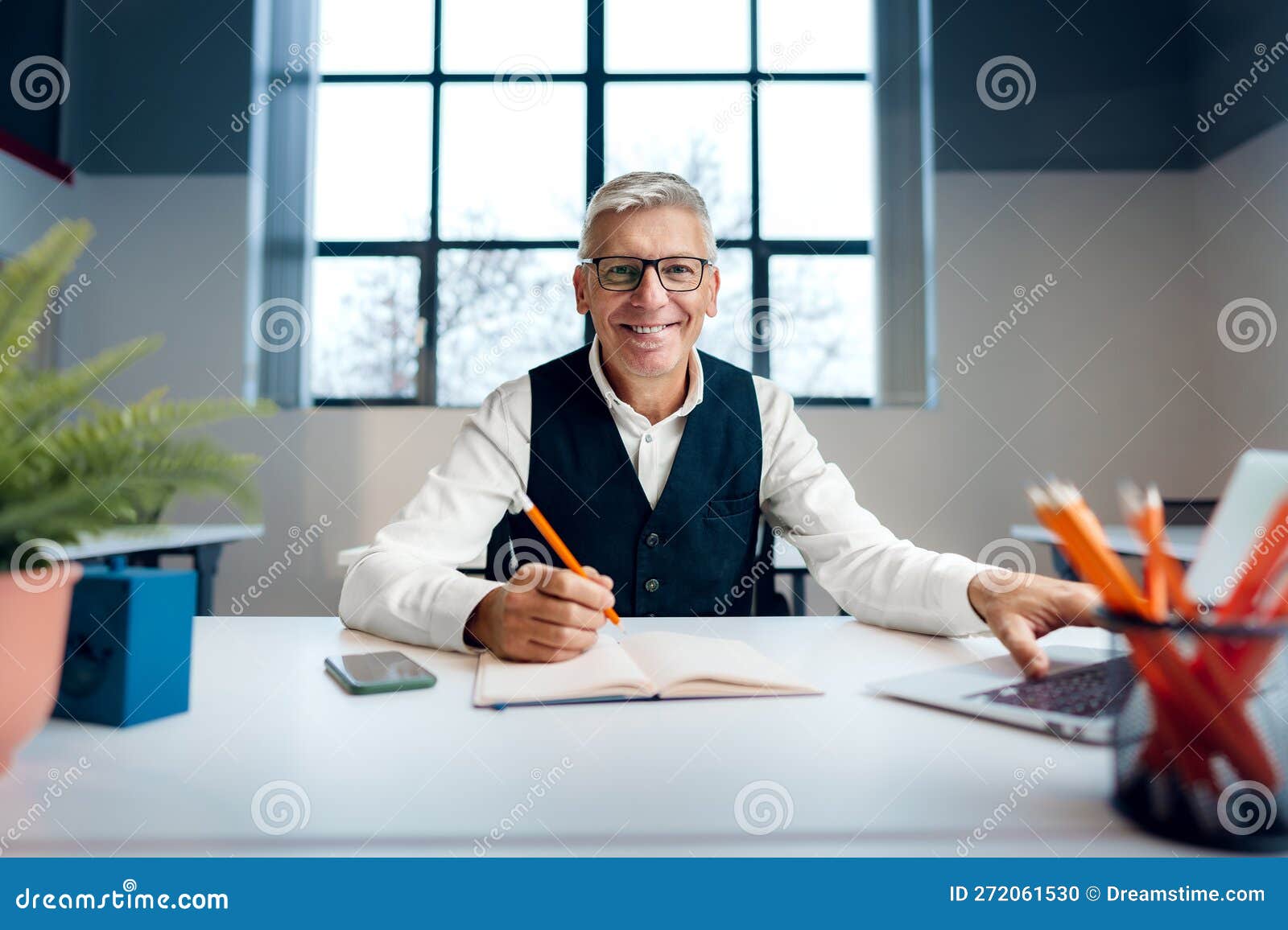 Busy Senior Man Sitting at Office Desk with Papers and Making Notes ...