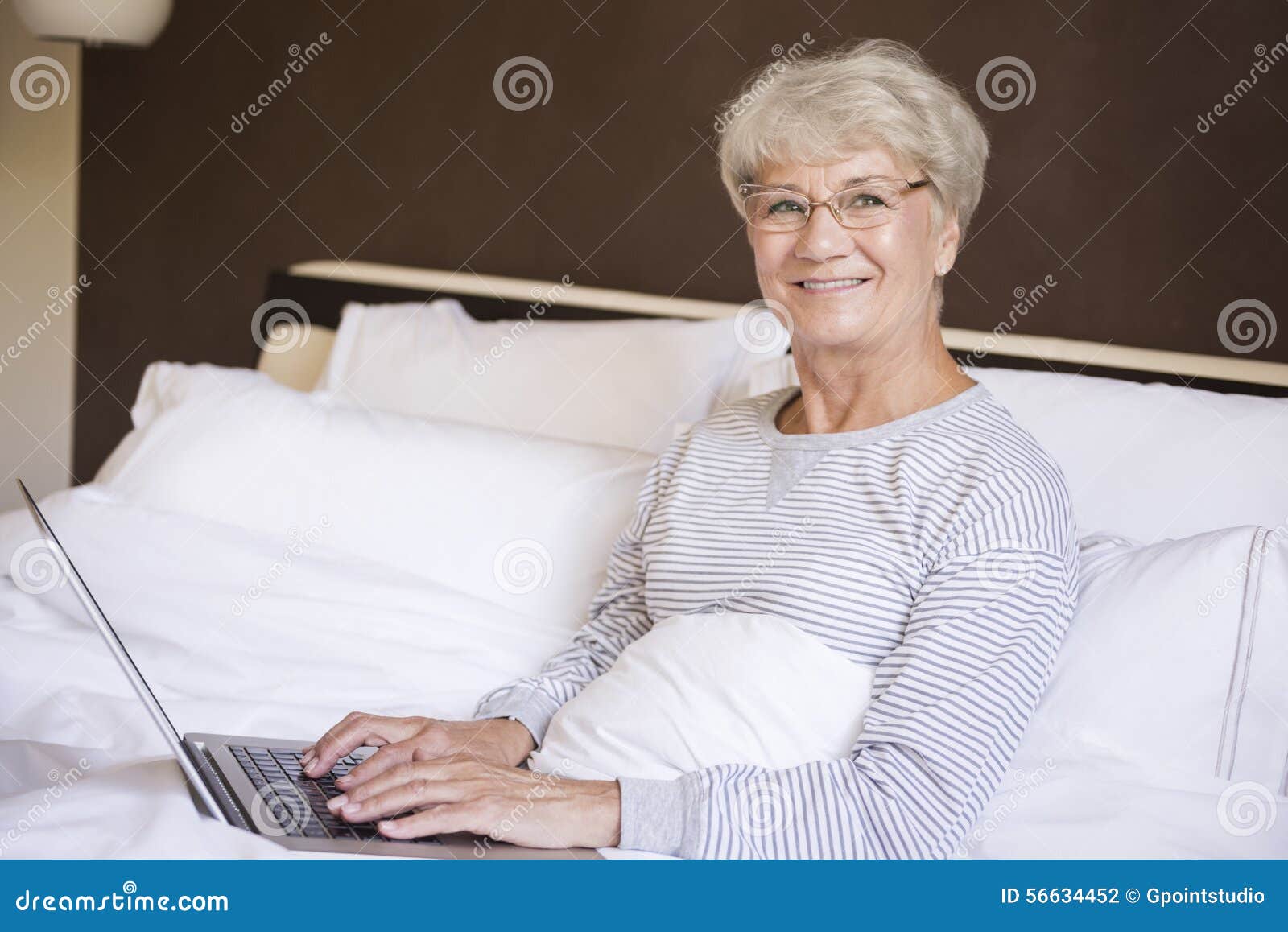 Busy senior woman in bed stock photo. Image of contemporary - 56634452