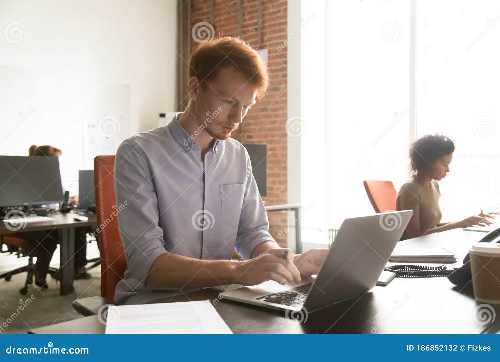 Busy Young Employee Intern Using Laptop Working With Documents Stock