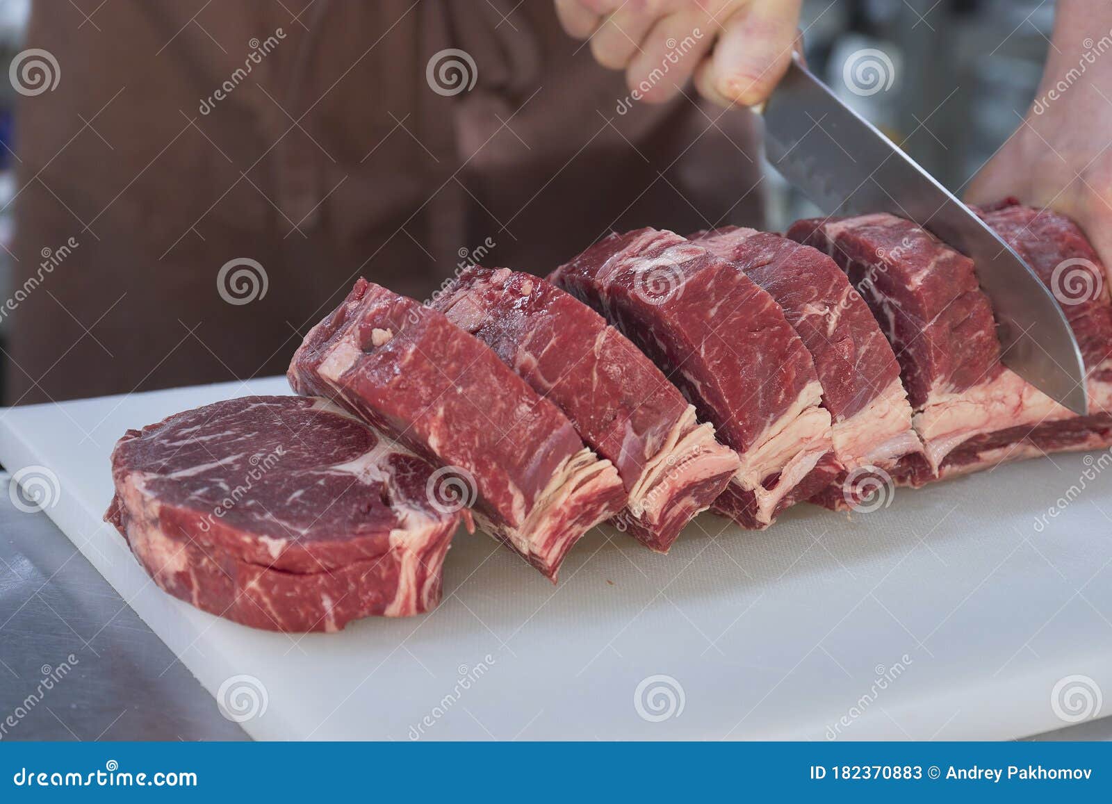 Butcher Cutting Beef in the Kitchen. Closeup of Hands with a Knife and ...