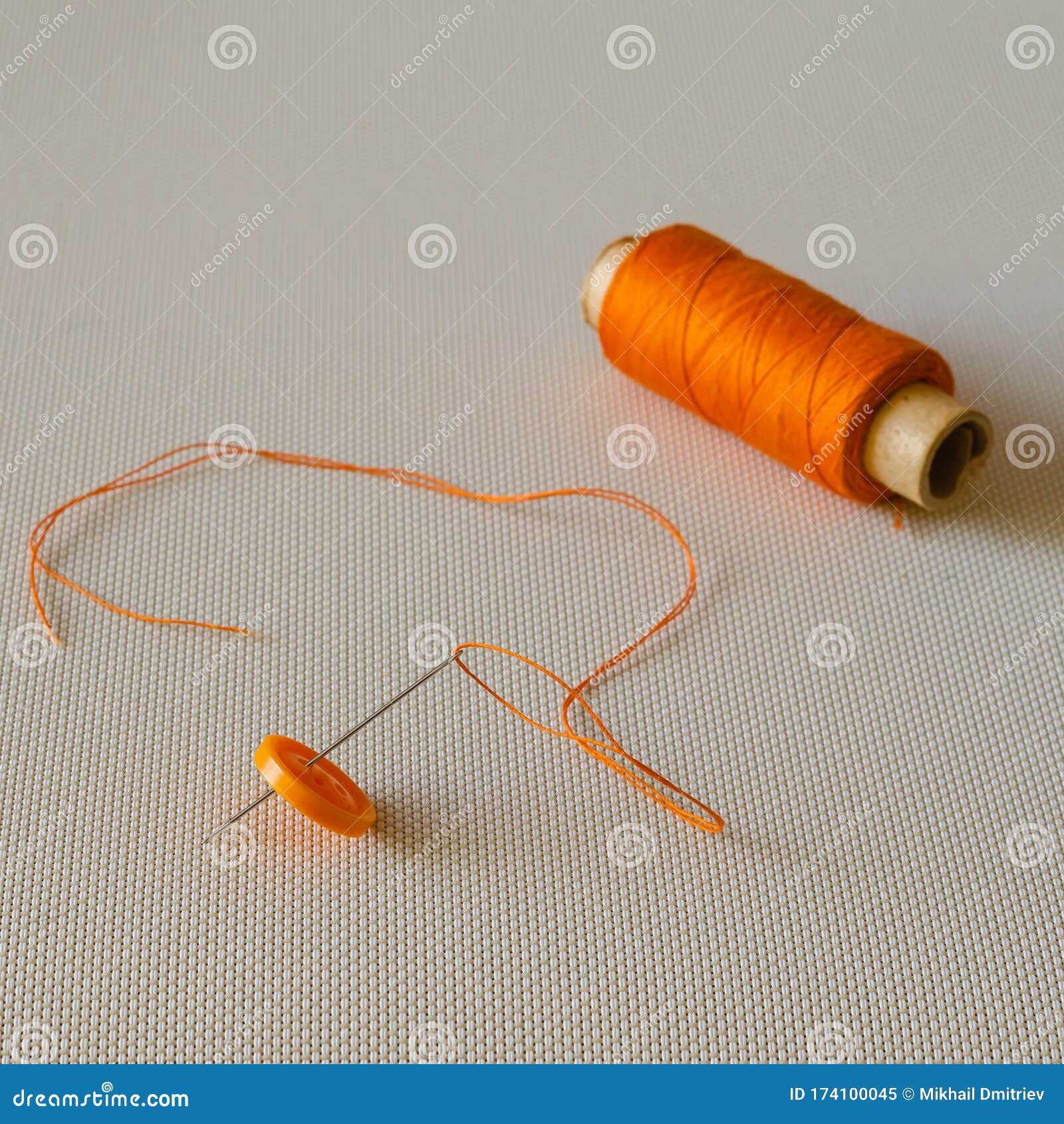 Button, Needle and Thread and Spool of Orange Thread Stock Image ...