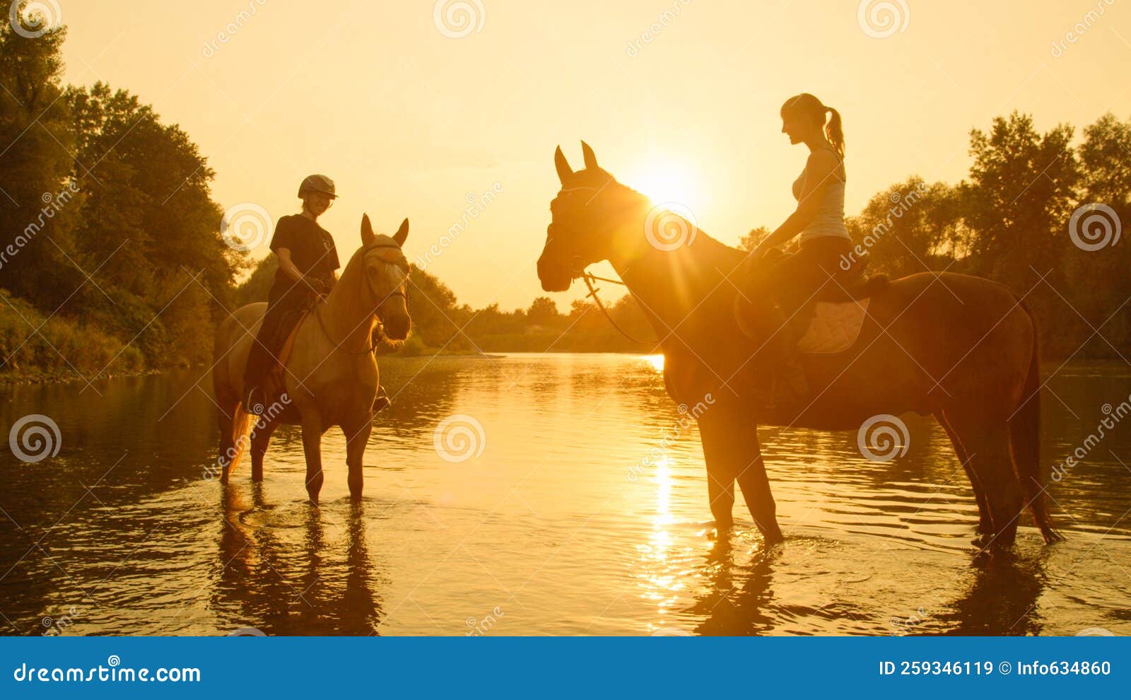 SUN FLARE: Morning Sun Rays Shine on the Women Riding Horses Along the ...