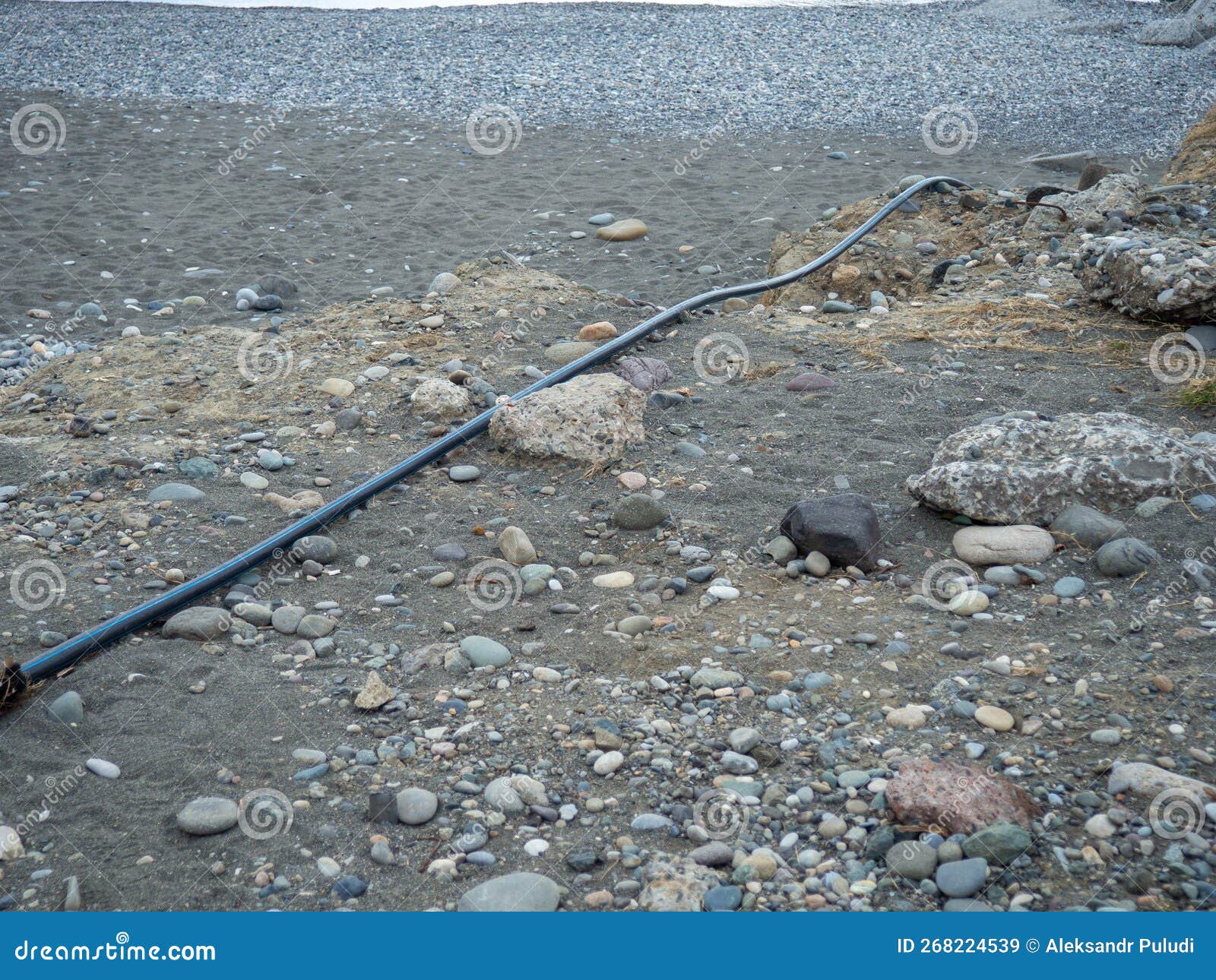 Cable on Black Sand. the Cable Sticks Out of the Ground. Electrical ...