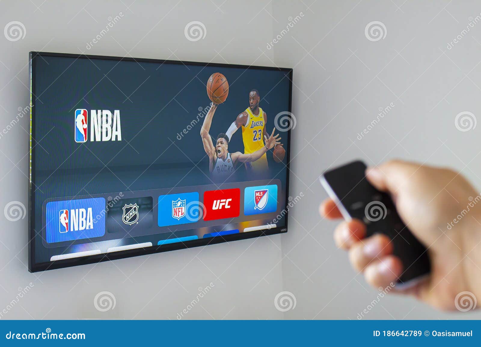 A Person Using an Apple Tv Remote Using the NBA Application. Concept ...