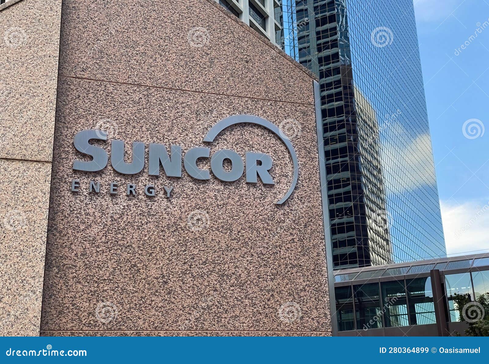 A Close Up To a Suncor Sign with Some Building on the Background ...