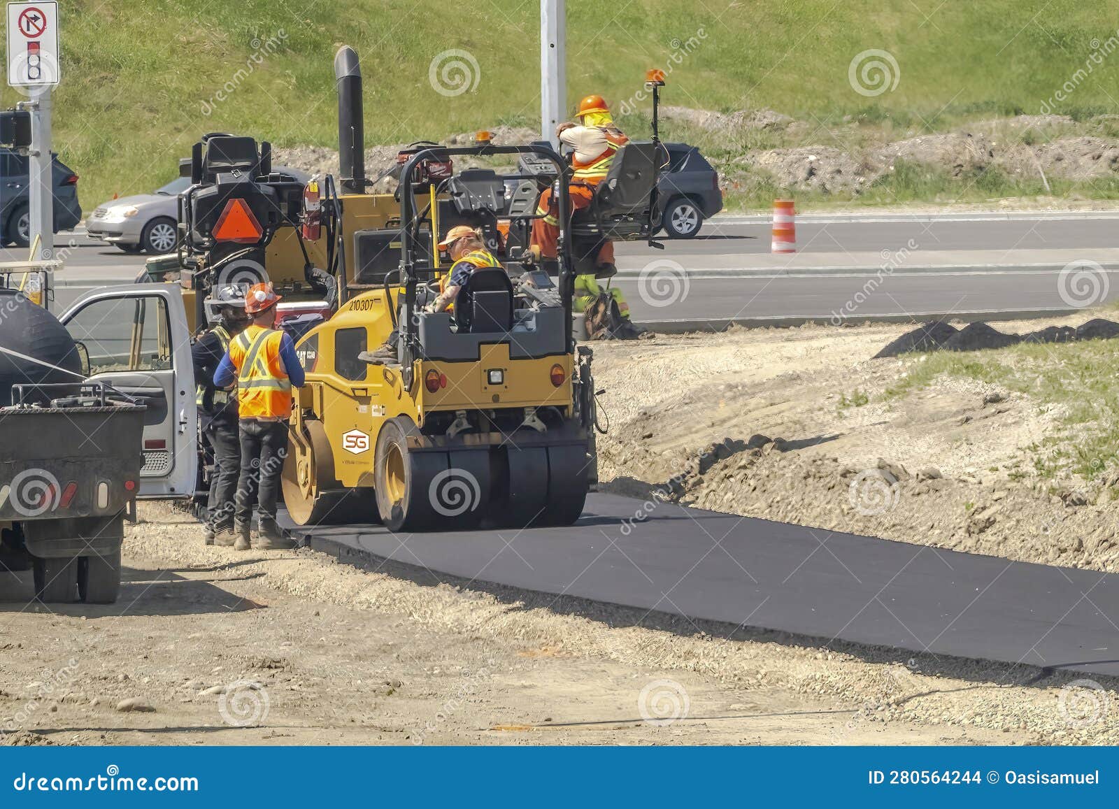 A Construction Worker Using a Cat Tandem Vibratory Roller To Compact ...