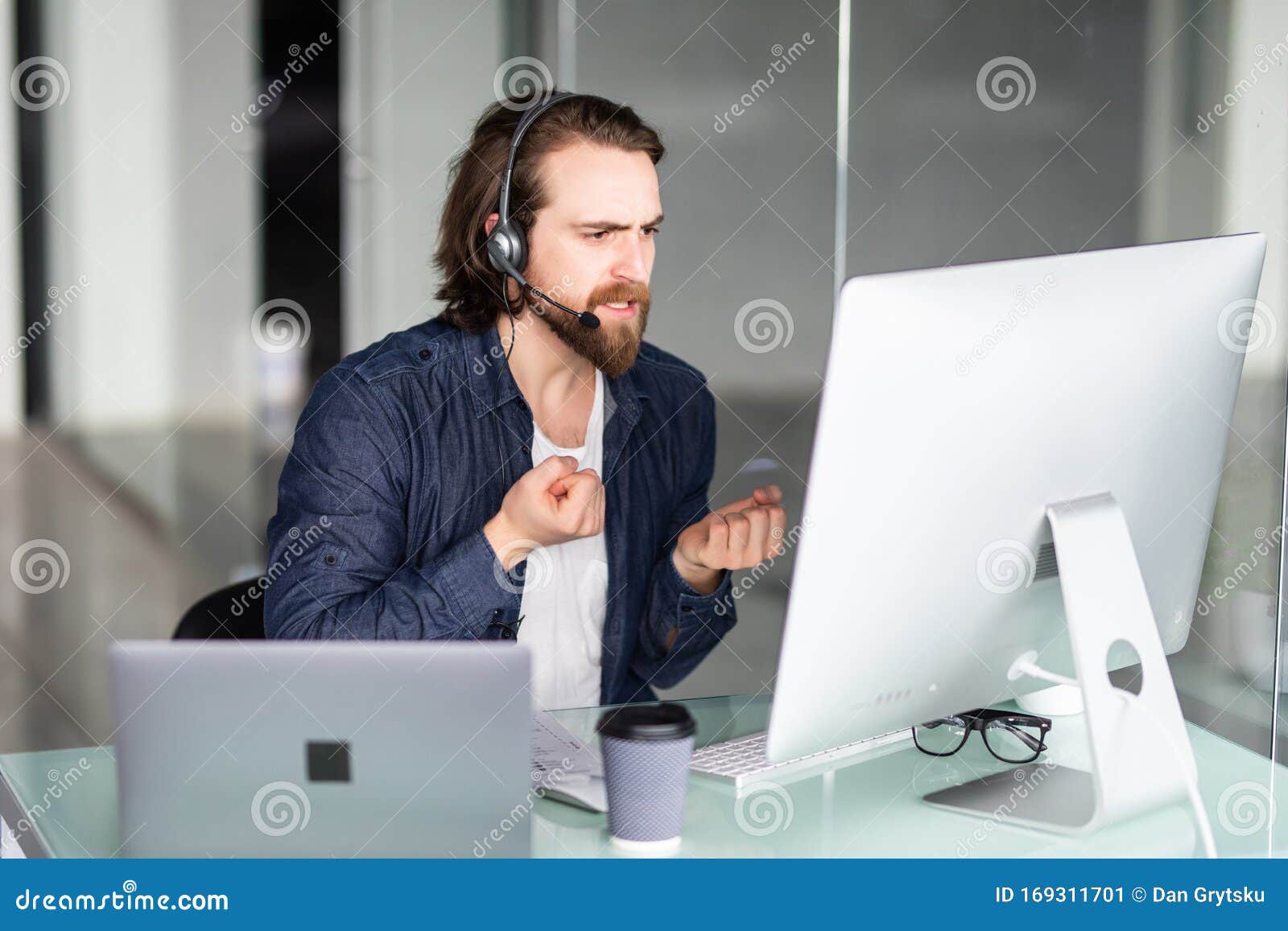 Angry Call Center Operator Working at His Desk on Computer and Laptop ...