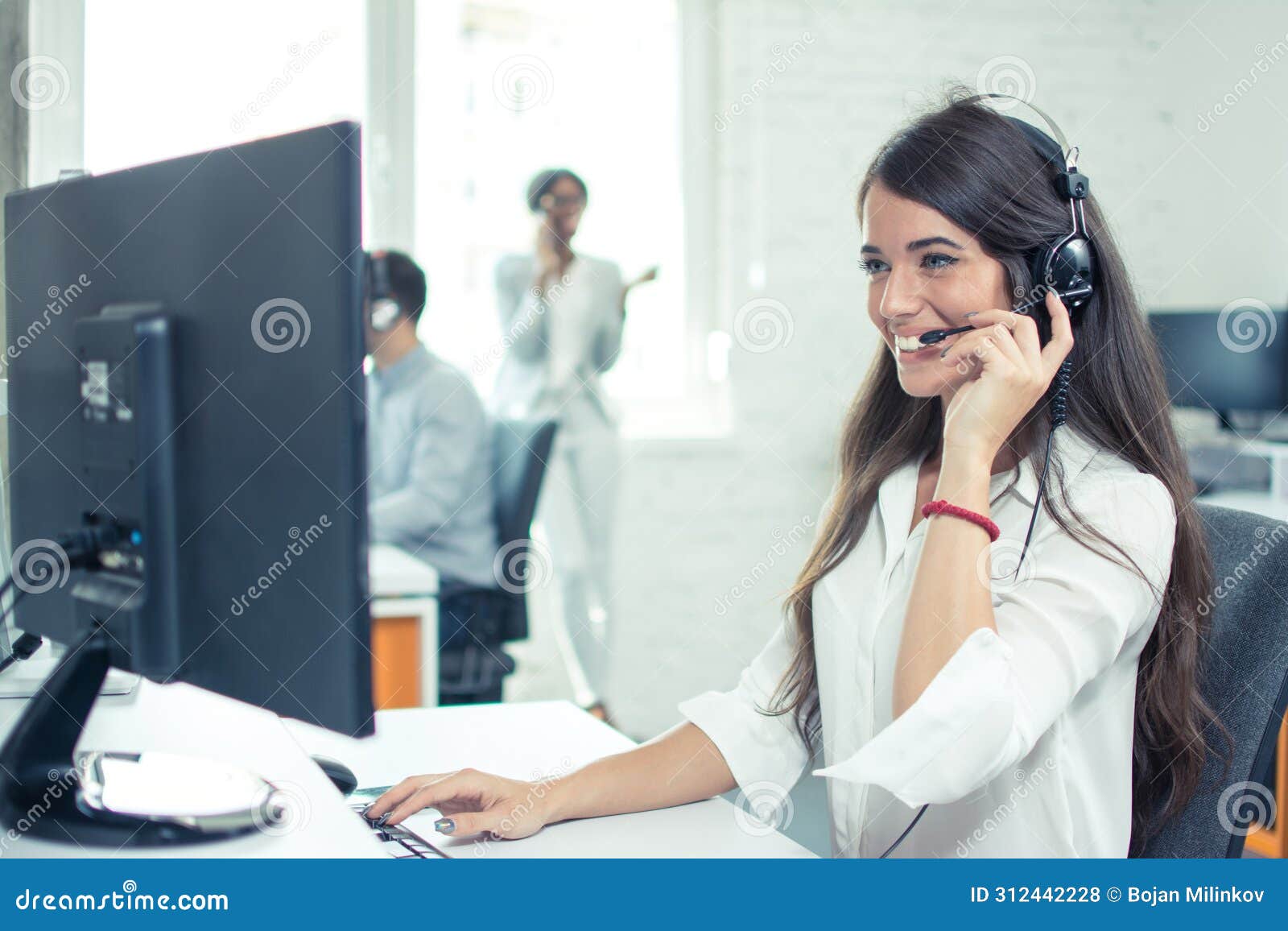Call Center Worker with Headset Working on Computer. Smiling Customer ...