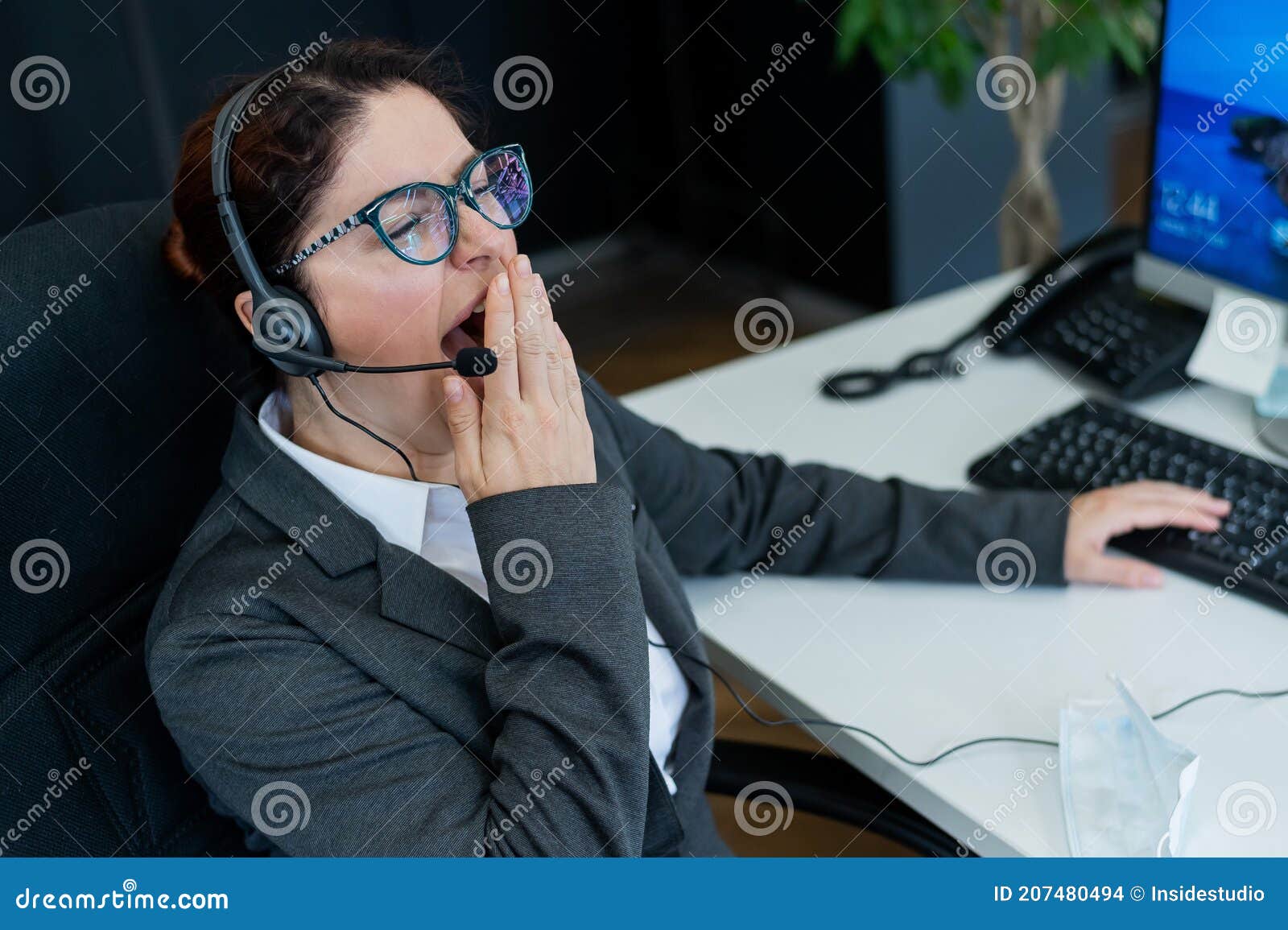 A Call Center Worker Yawns at His Desk Stock Photo - Image of lazy ...