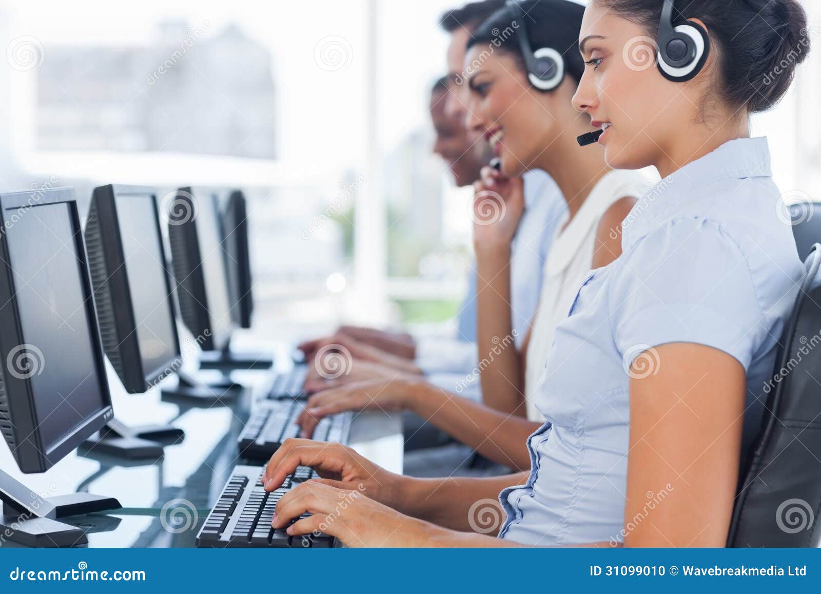 Call Centre Workers Sitting in Line while Helping People Stock Photo ...