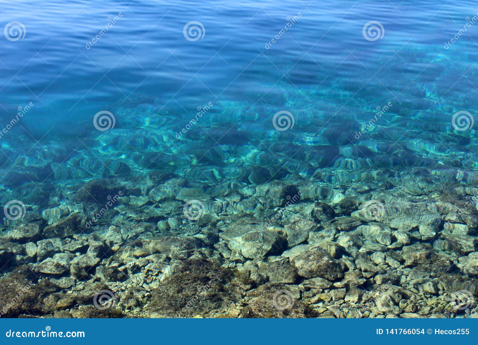 Calm Blue Sea with Clearly Visible Rocks on Bottom Going from Shallow ...