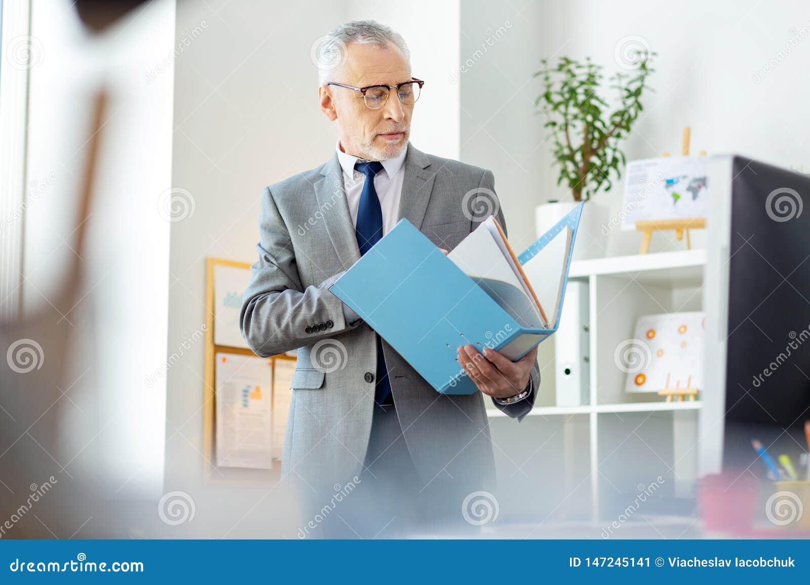 Calm Grey-haired Man Flipping through Papers in Spacious Fold Stock ...