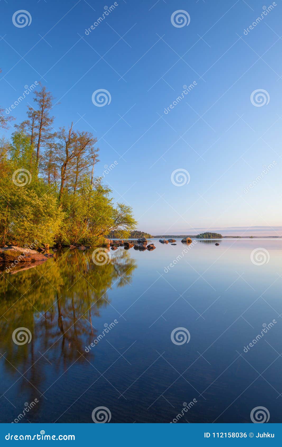 Calm lakeside at sunset stock photo. Image of lakefront - 112158036