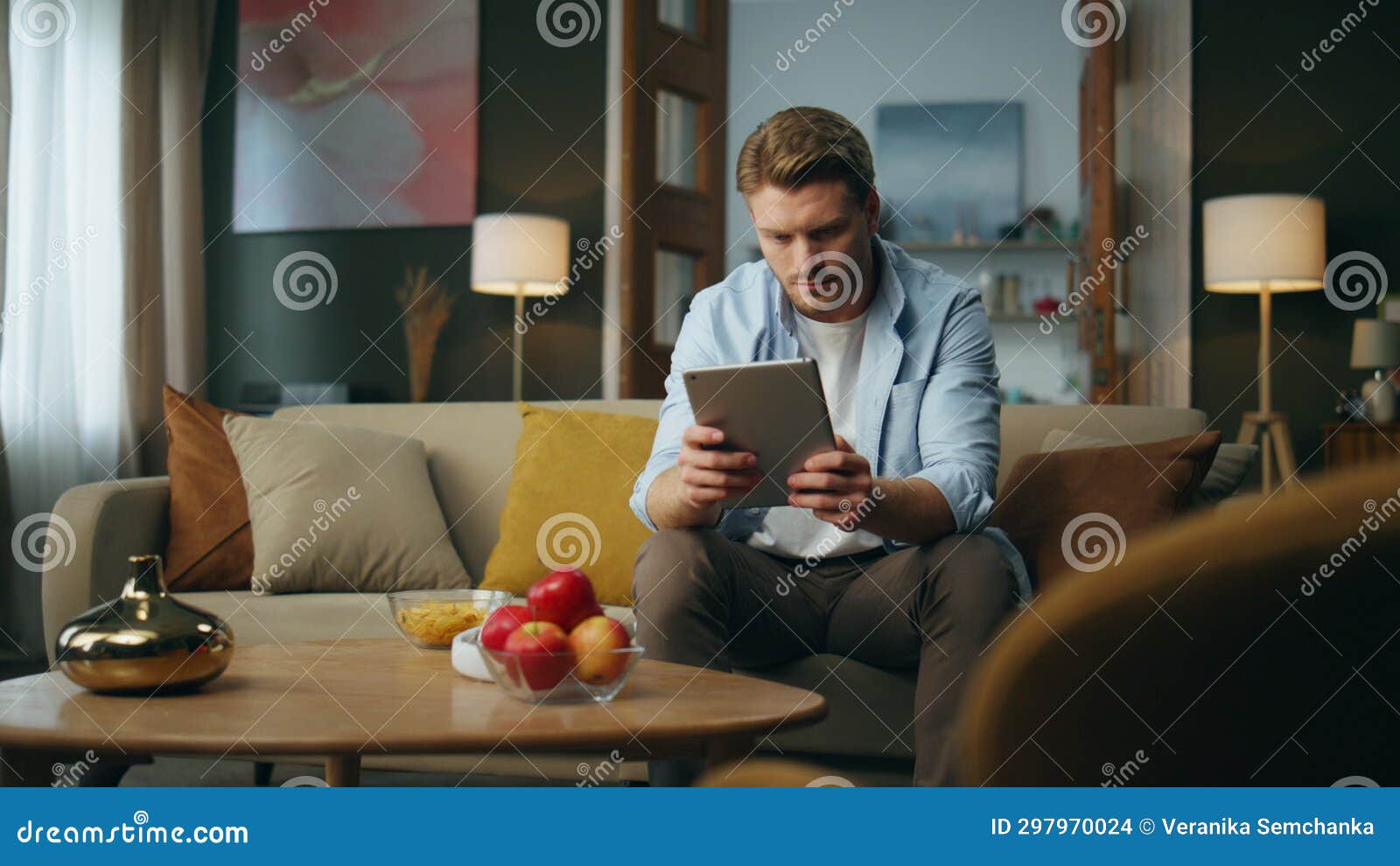Calm Man Browsing Tab Device at Home. Serious Guy Sitting Sofa ...