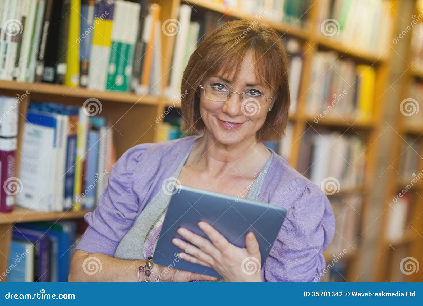 Calm Mature Librarian Working with Her Tablet in Library Stock Photo ...