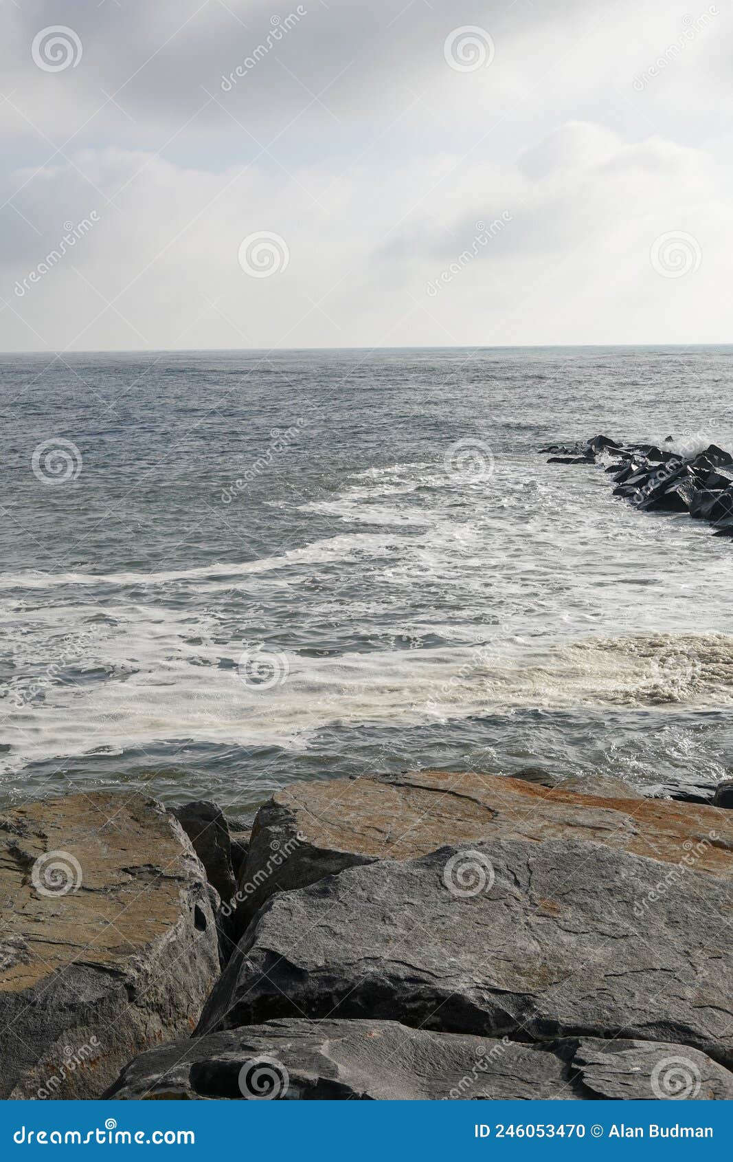 Calm Ocean Inlet with Boulder Jetty As Dark Storm Clouds Approach Stock ...