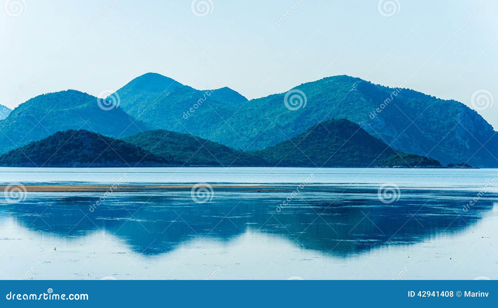 Calm Sea with Distant Mountains and Reflection in Water Stock Photo ...