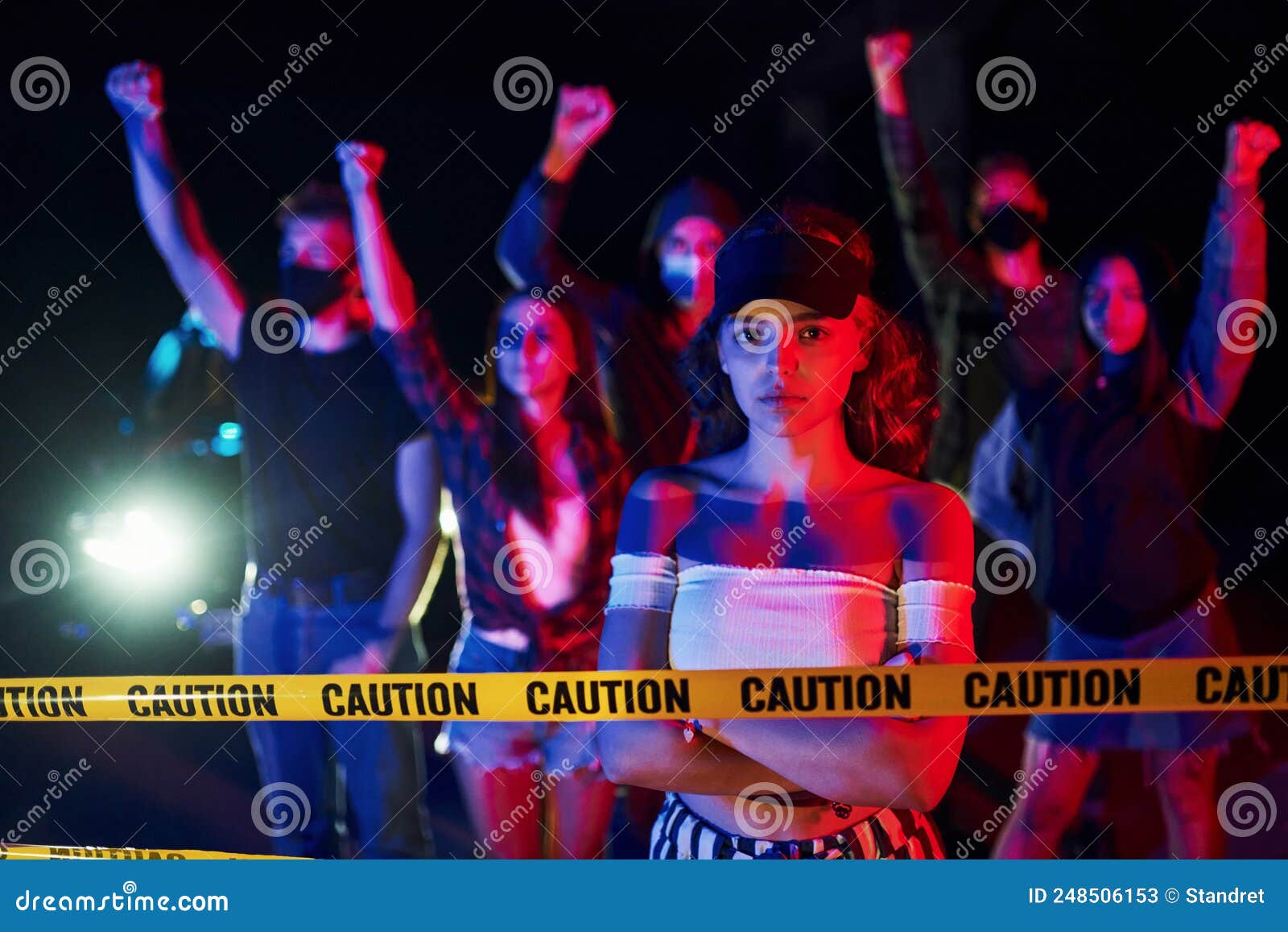 Calm Woman Standing In Front Of Crowd Group Of Protesting Young People
