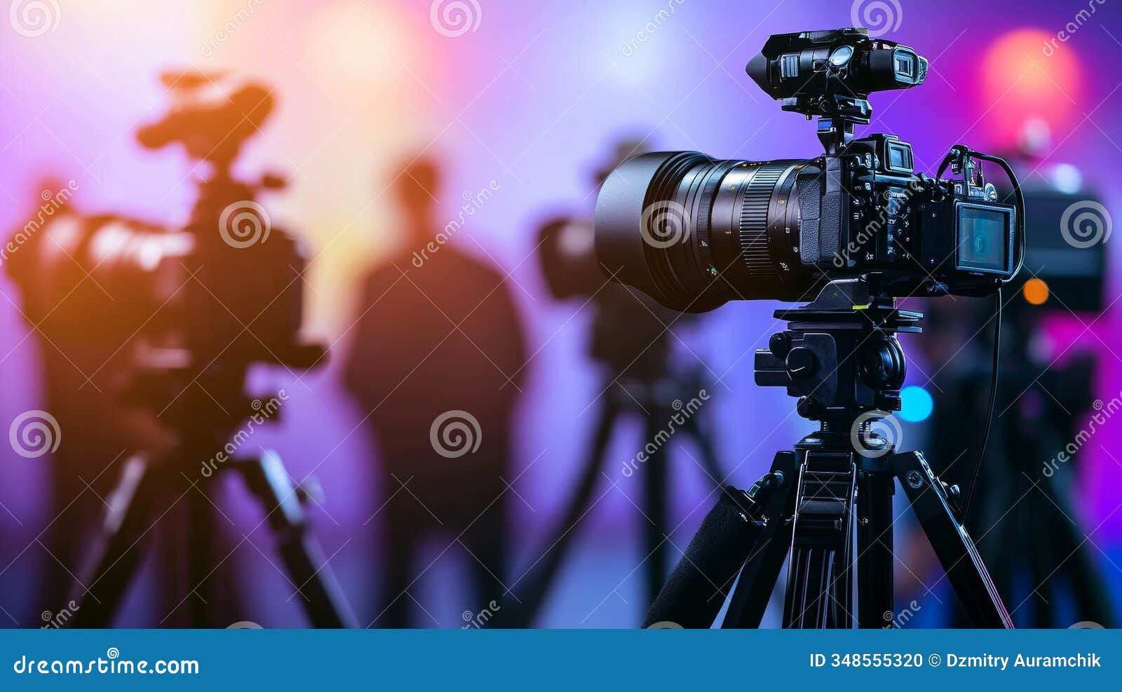 A Camera Positioned in Front of a Stage, with Lights Shining and People ...