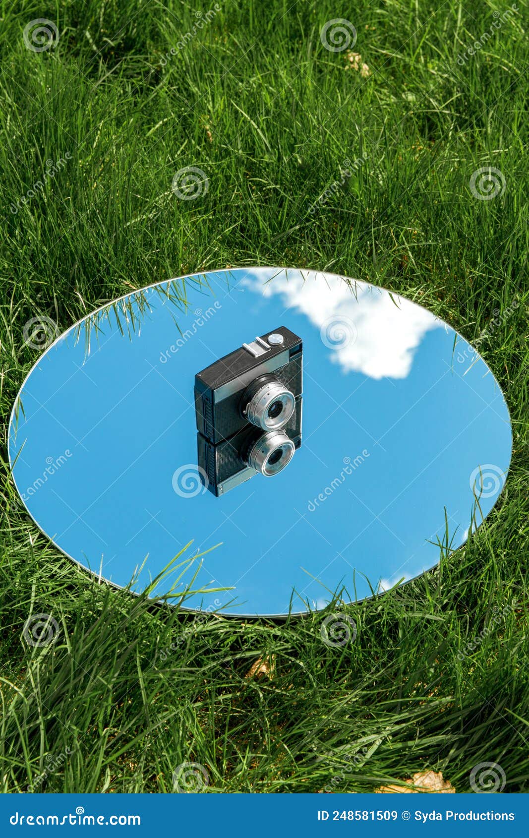 Camera and Sky Reflection in Round Mirror on Grass Stock Image - Image ...