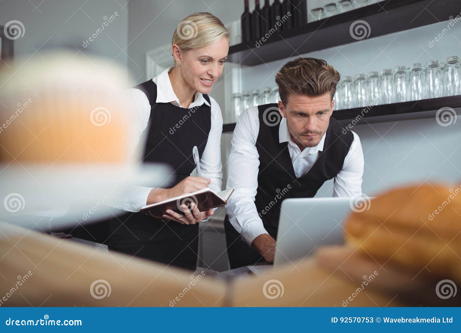 Camerieri Che Per Mezzo Del Computer Portatile Al Contatore Immagine ...