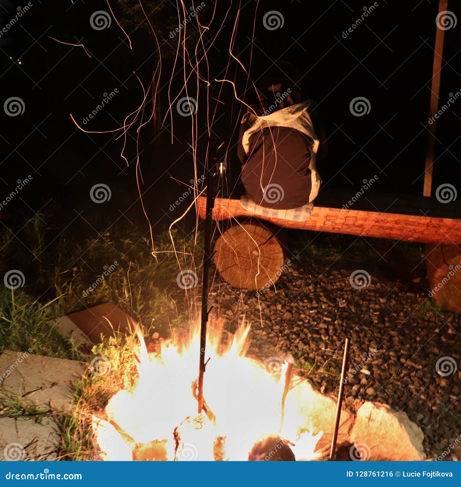A Campfire and a Bench with Someone Sitting There Stock Photo - Image ...