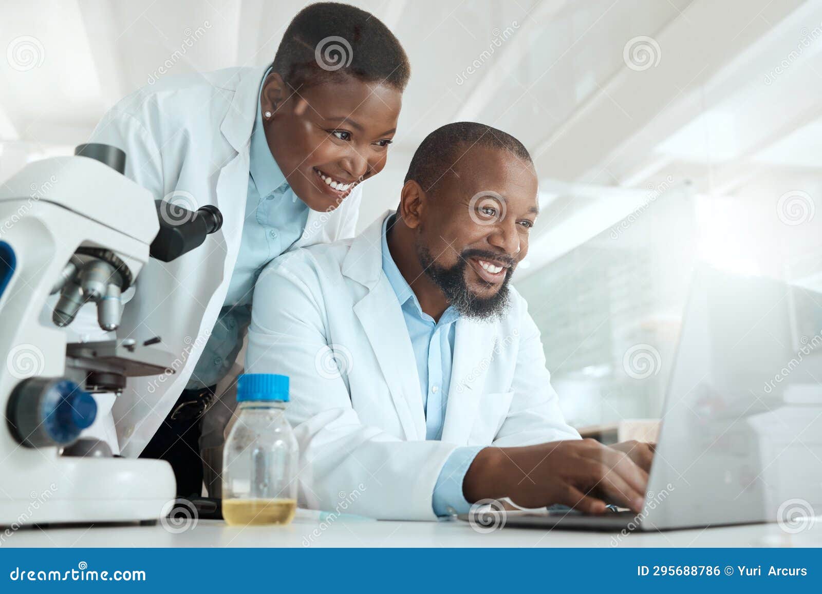 We Can Discover a Cure Together. Two Scientists Using a Laptop in a ...