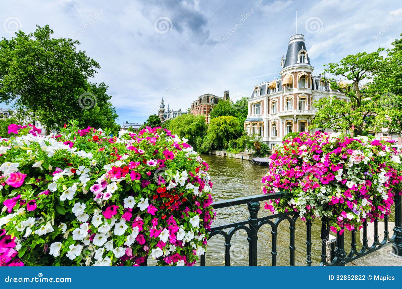 Canal in Amsterdam with Flowers on a Bridge Stock Photo - Image of ...