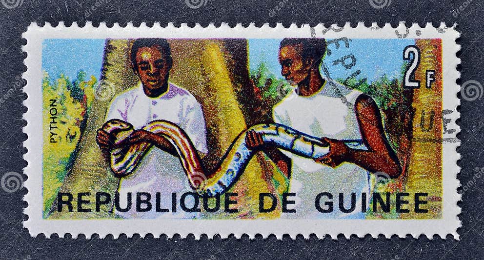 Cancelled Postage Stamp Printed by Guinea, that Shows Men Holding Rock ...