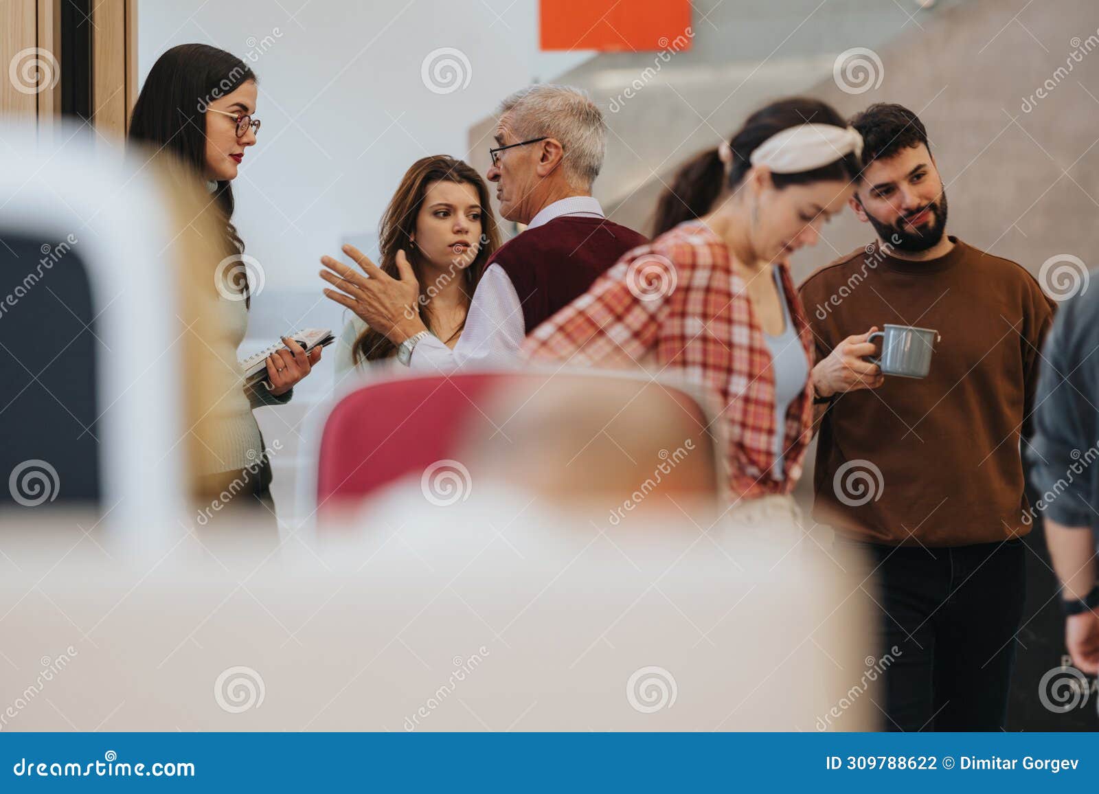 A Candid Scene of Mixed-age Colleagues Engaging in a Conversation at ...