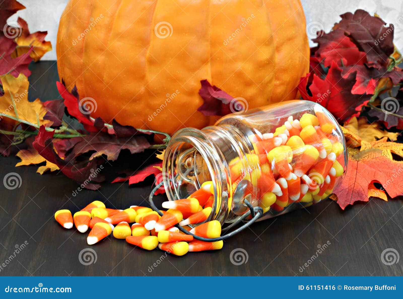 Candy Corn in a Mason Jar Spilling Onto a Table Decorated for Au Stock ...