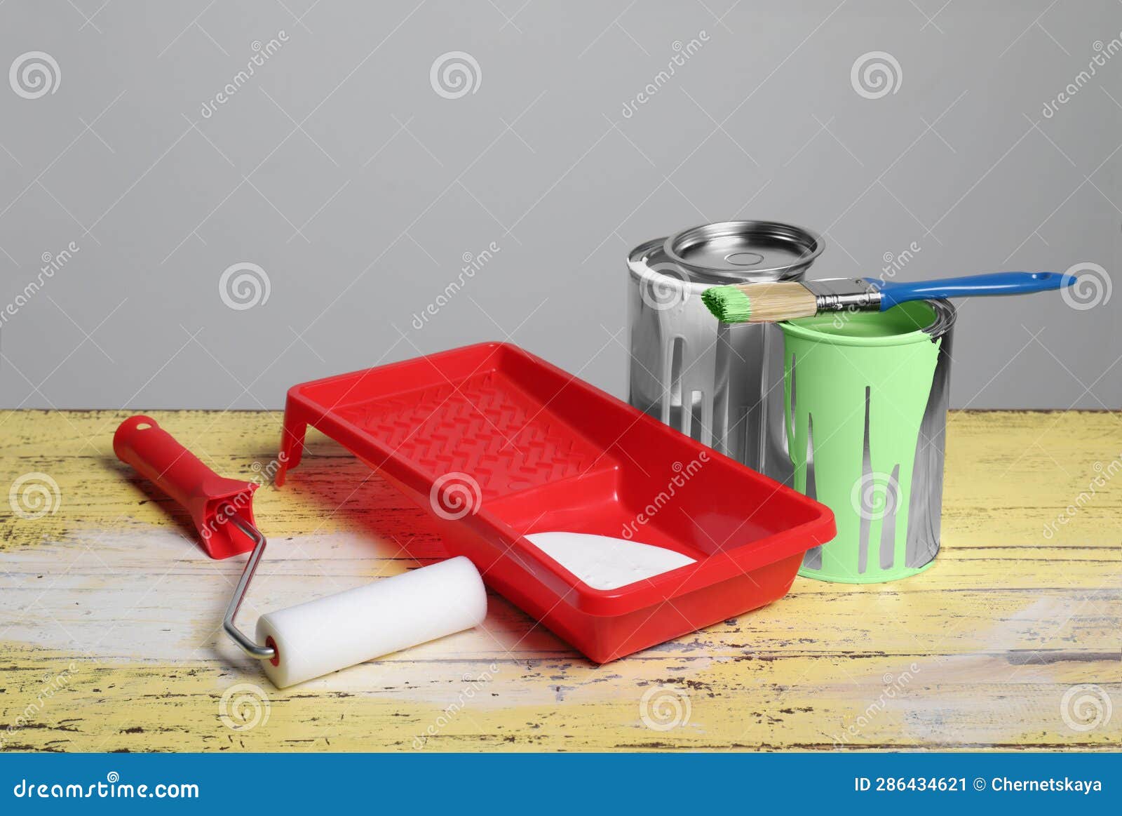 Cans of Paints, Brush, Roller and Tray on Yellow Wooden Table Stock ...