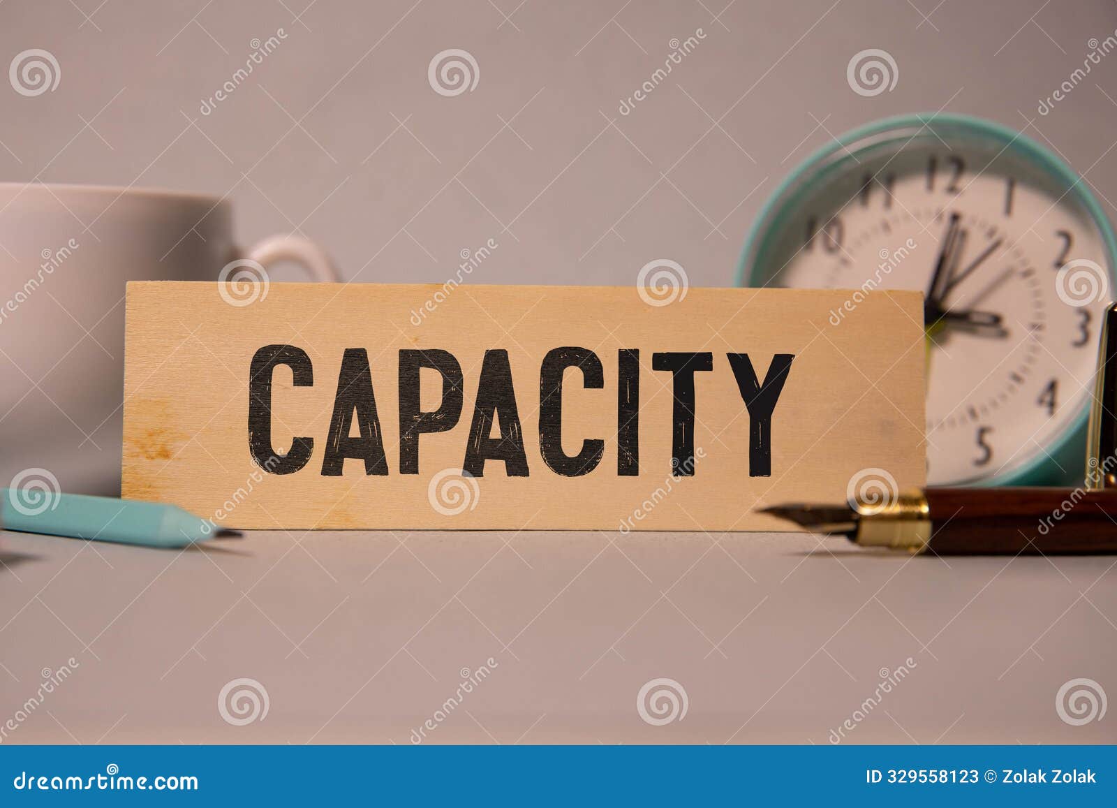 CAPACITY Text on a Strip of Wood Lying on a White Table. Stock Image ...
