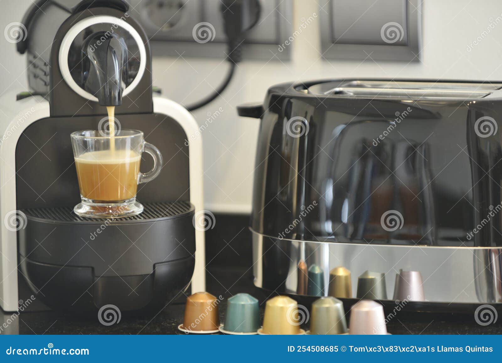 Capsule Coffee Maker on a Black Countertop, a Plug and a Transparent ...